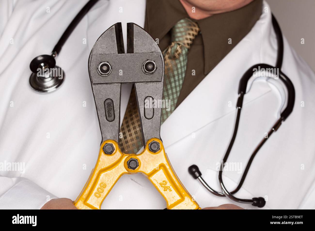 Doctor with stethoscope holding a pair of cable cutters hi-res stock ...