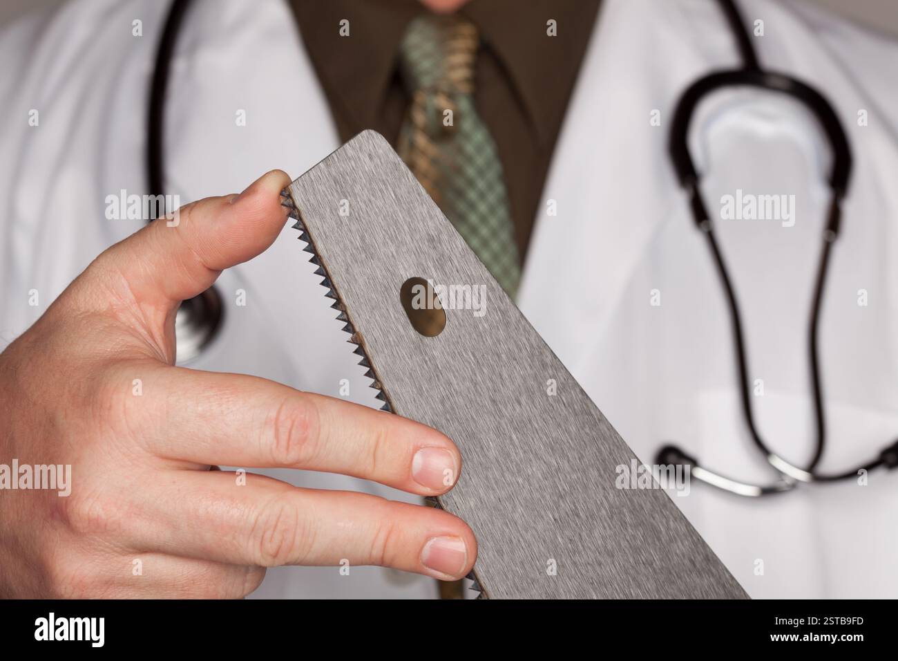 Doctor with stethoscope holding a very sharp saw hi-res stock ...