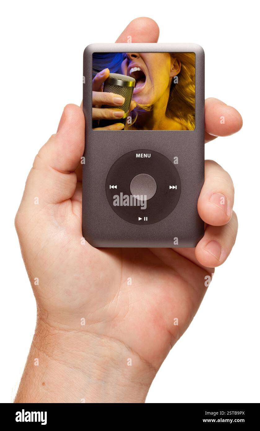 Man's Hand Holding Electronic Gadget with Female Singer on Screen ...