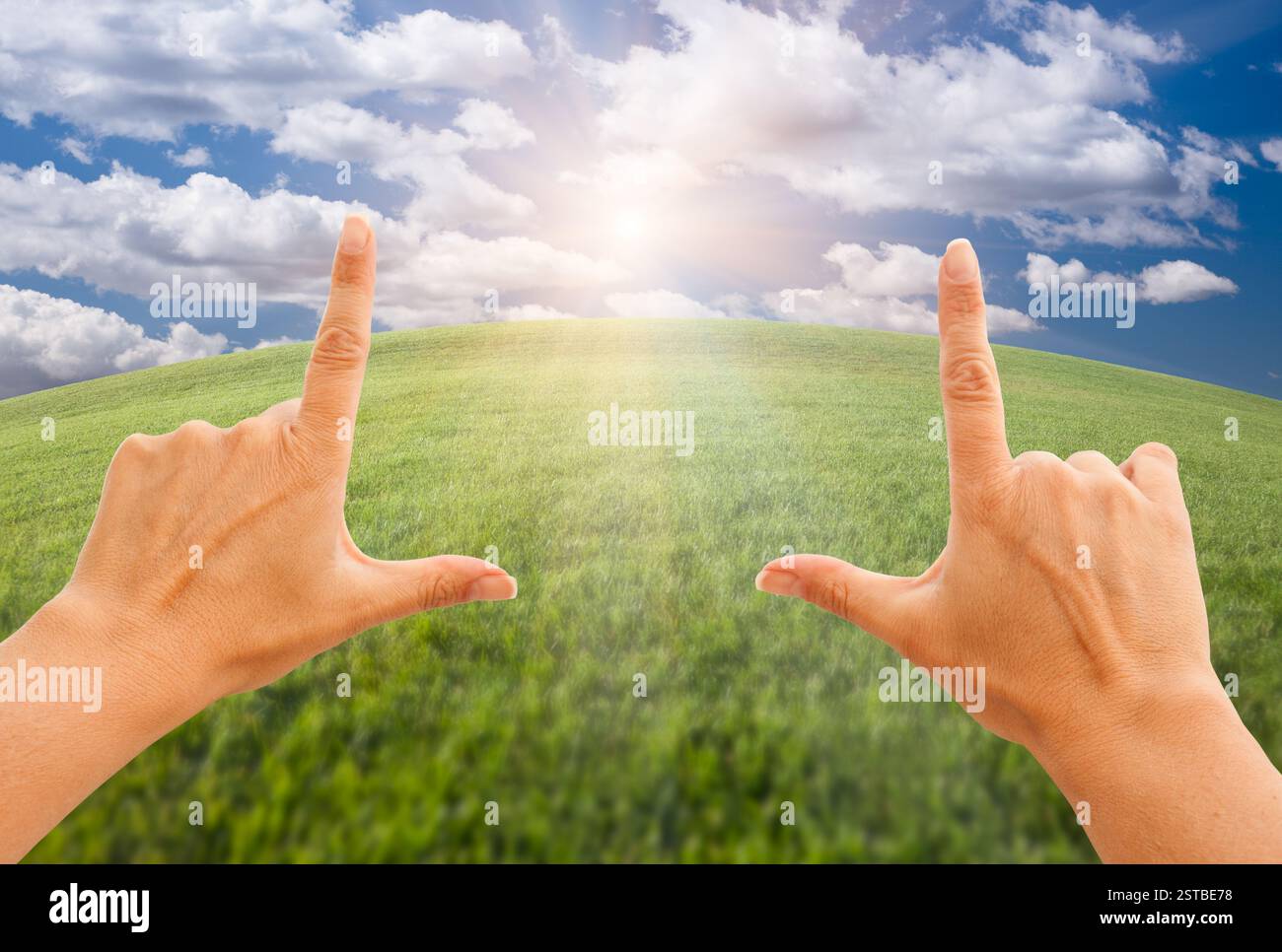 Female hands making frame over arched horizon of grass field hi-res ...