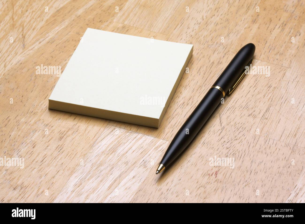Pen and Post It Notes Pad Against a Wood Background Stock Photo - Alamy