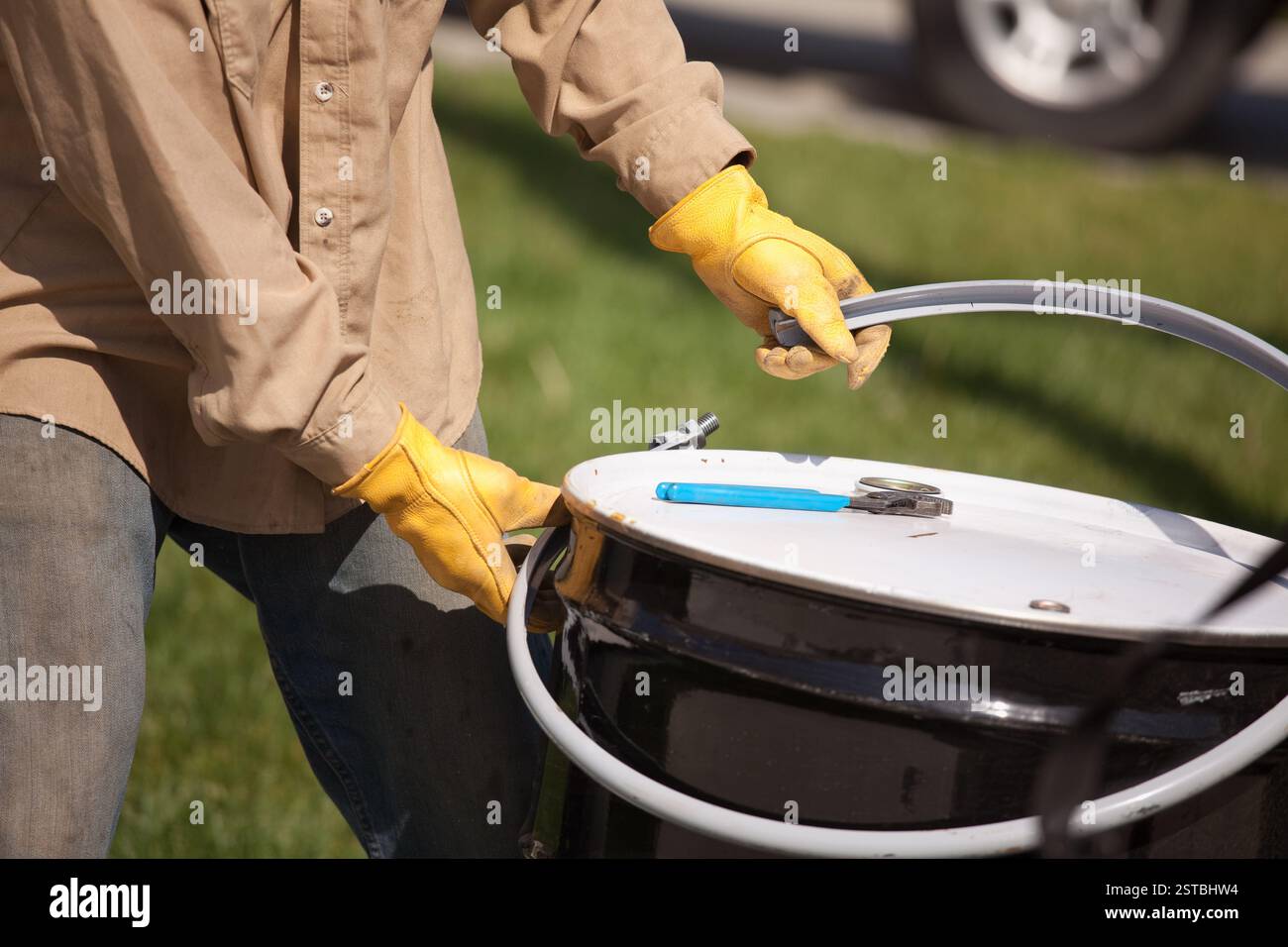 Worker Opening or Sealing Utility Drum Stock Photo - Alamy