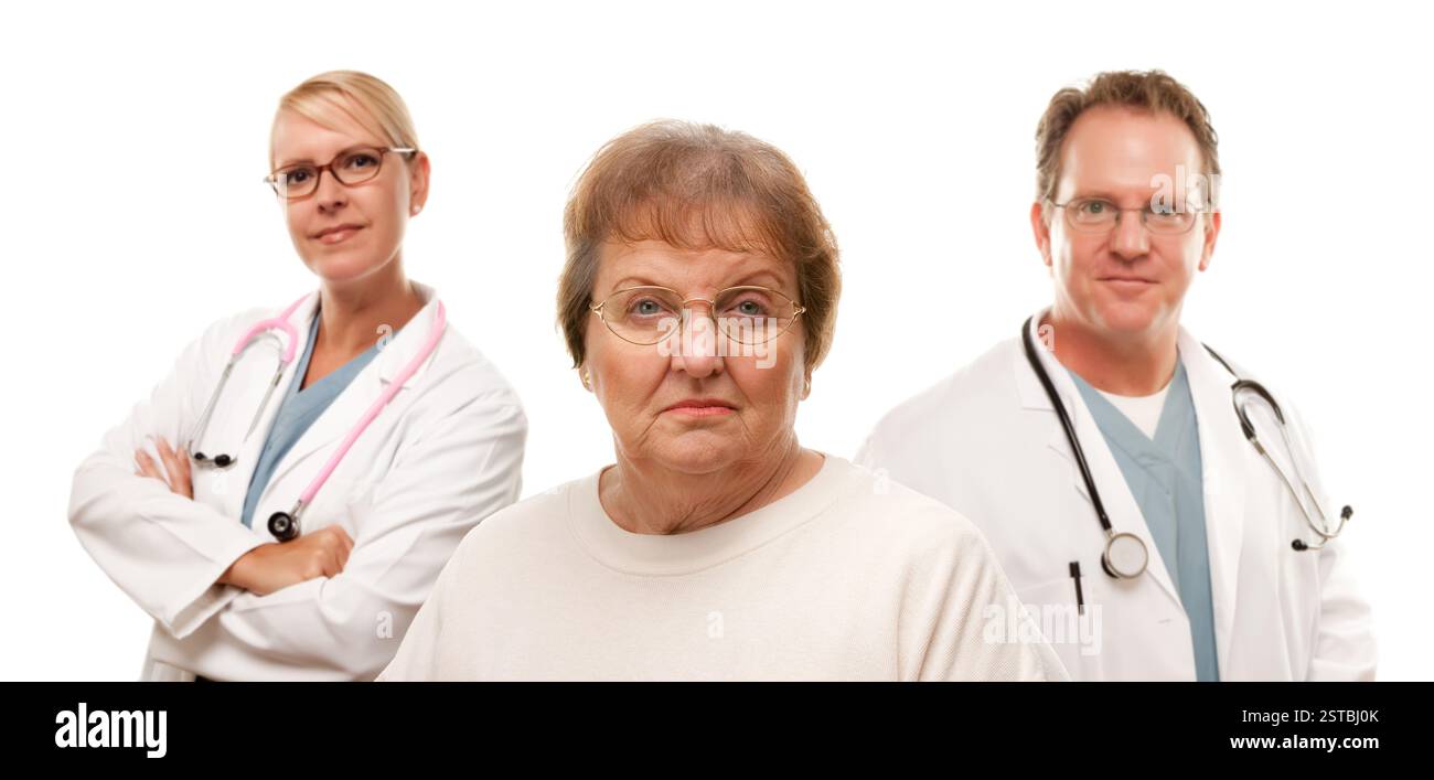 Concerned Senior Woman with Doctors Behind Isolated on a White ...
