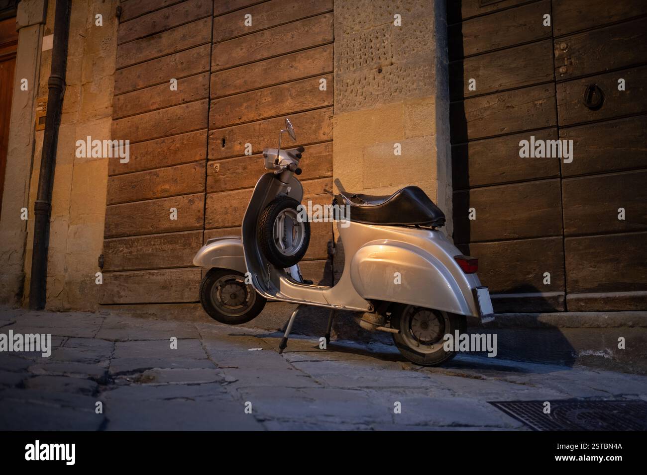 A classic moped Scooter type motorcycle parked in an old street in ...