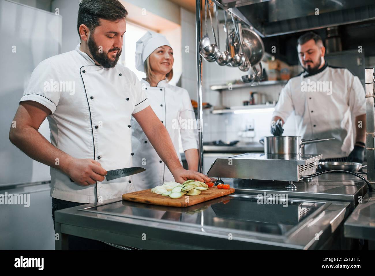 Team making salad. Professional chef preparing food in the kitchen ...