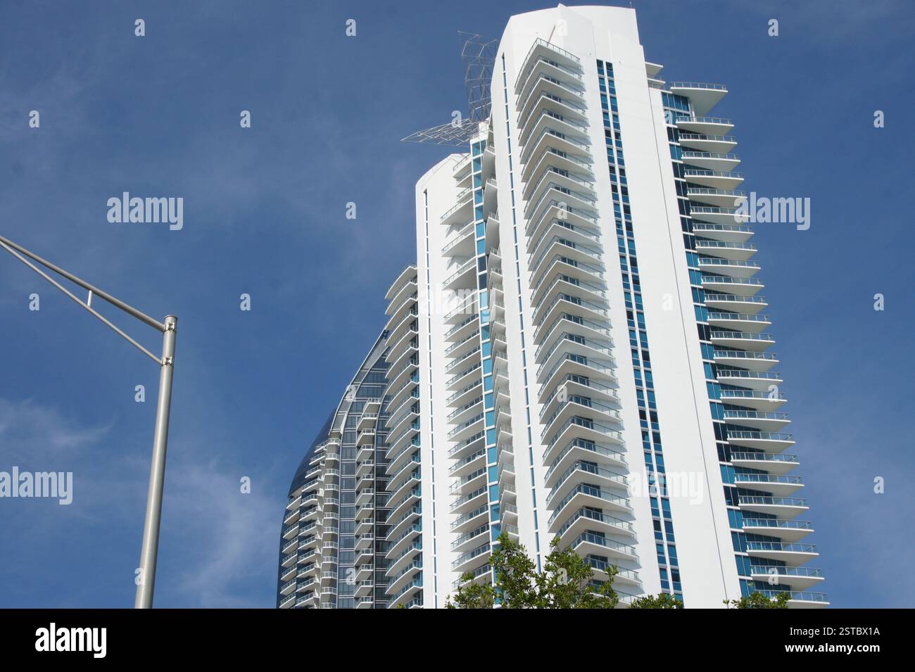 A Miami high-rise condo tower glitters at night. Its modern glass ...