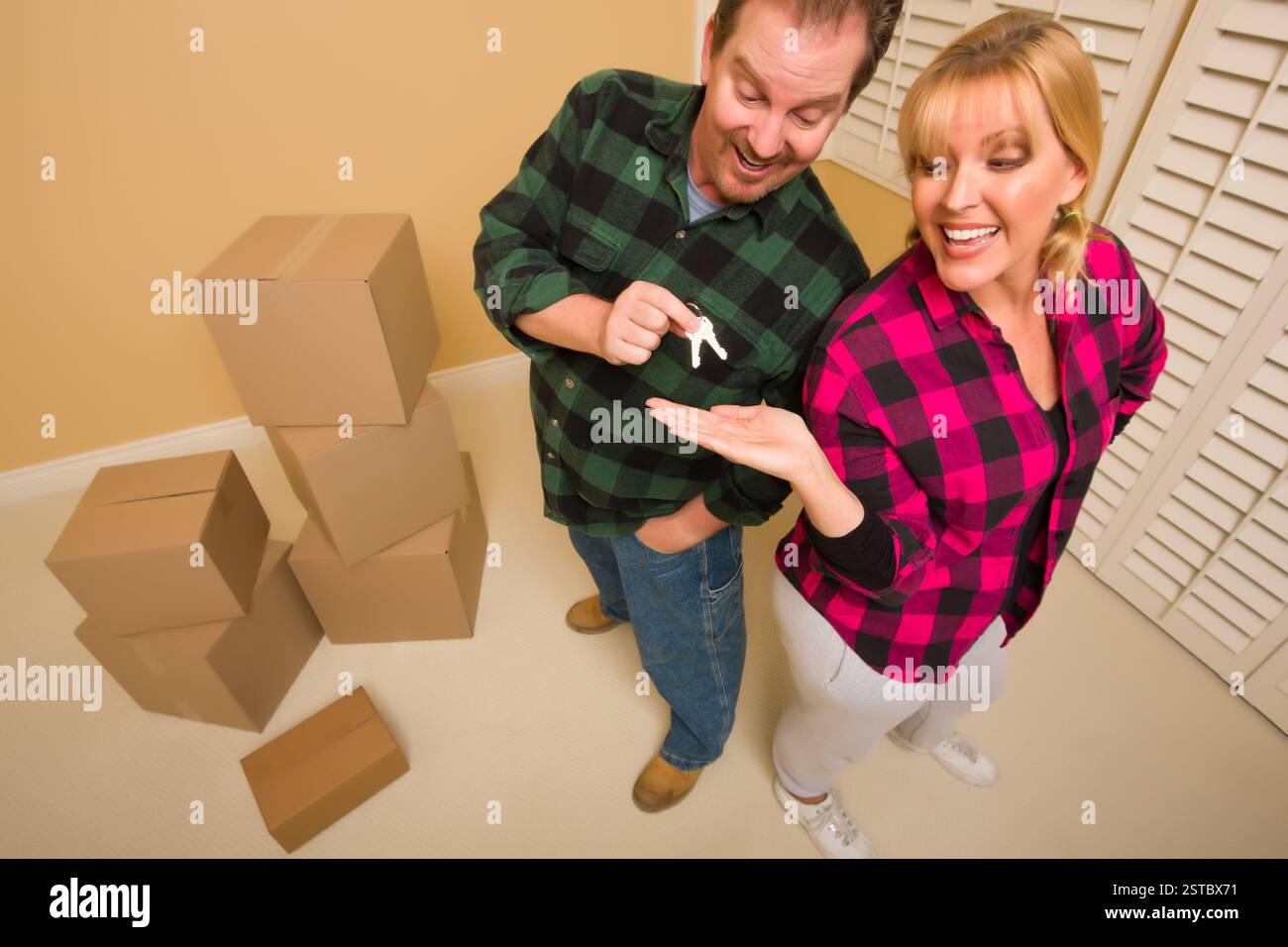 Goofy Excited Man Handing Keys to Smiling Wife Stock Photo - Alamy