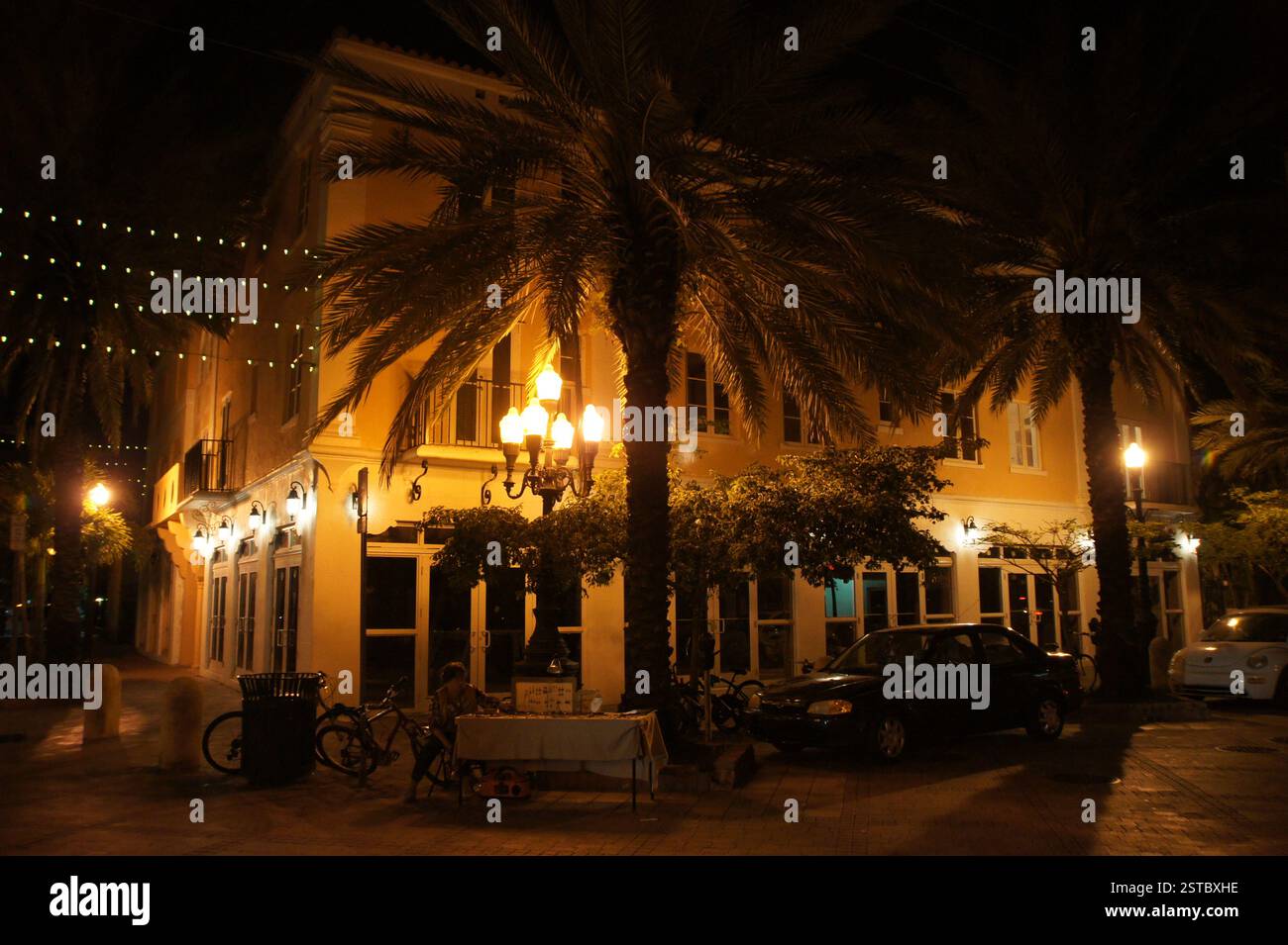Miami. Silver sleek car parked on a city street at night. Streetlights ...