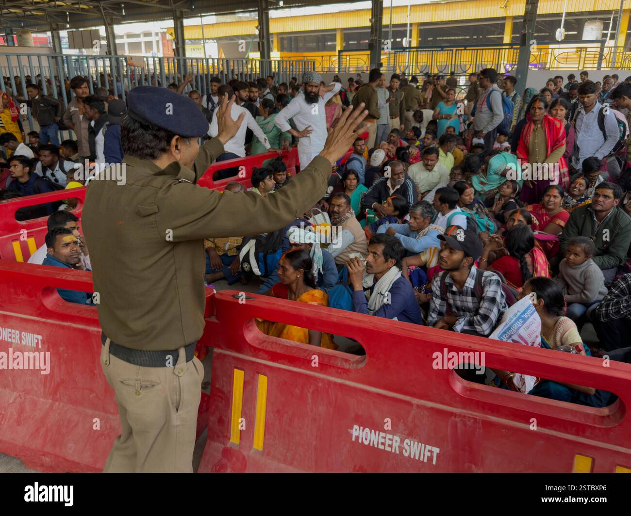 An Indian police man (RPF) controls a crowd at Prayagraj Junction ...