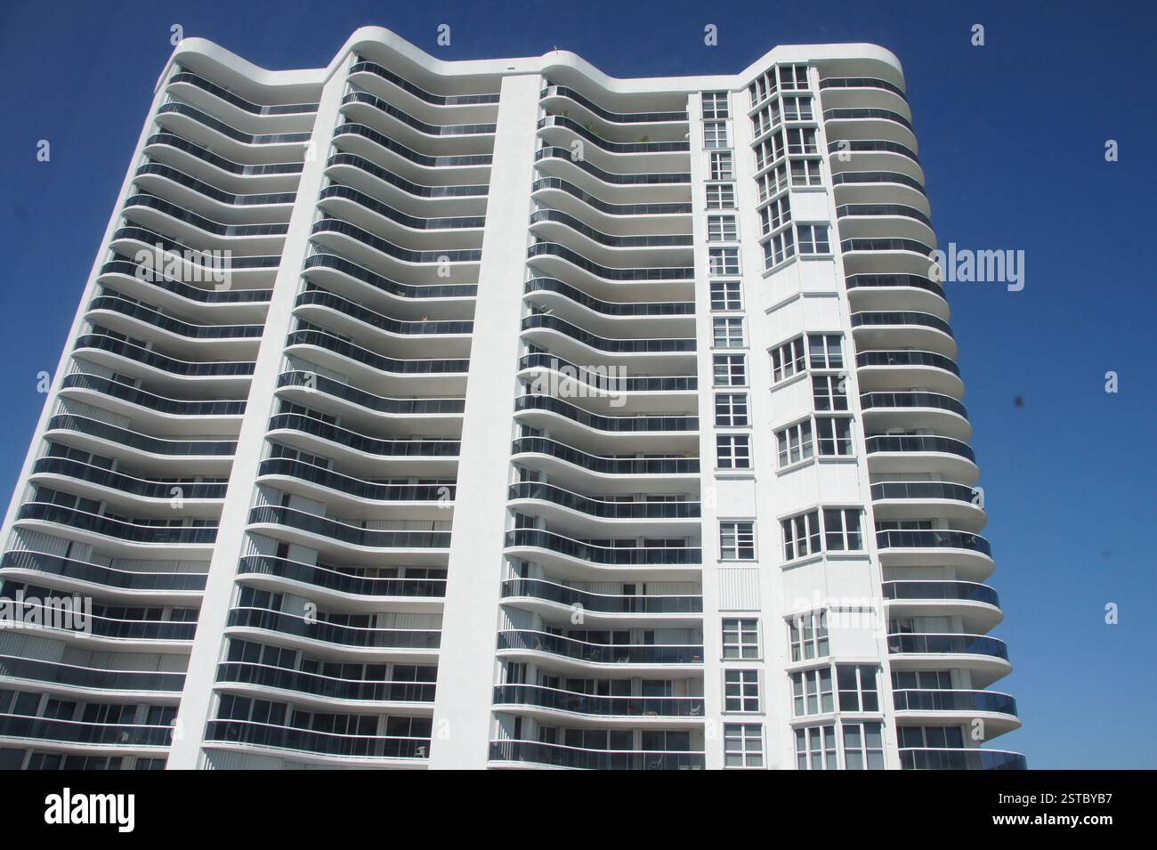 A sleek, high-rise apartment building in Miami boasts balconies ...