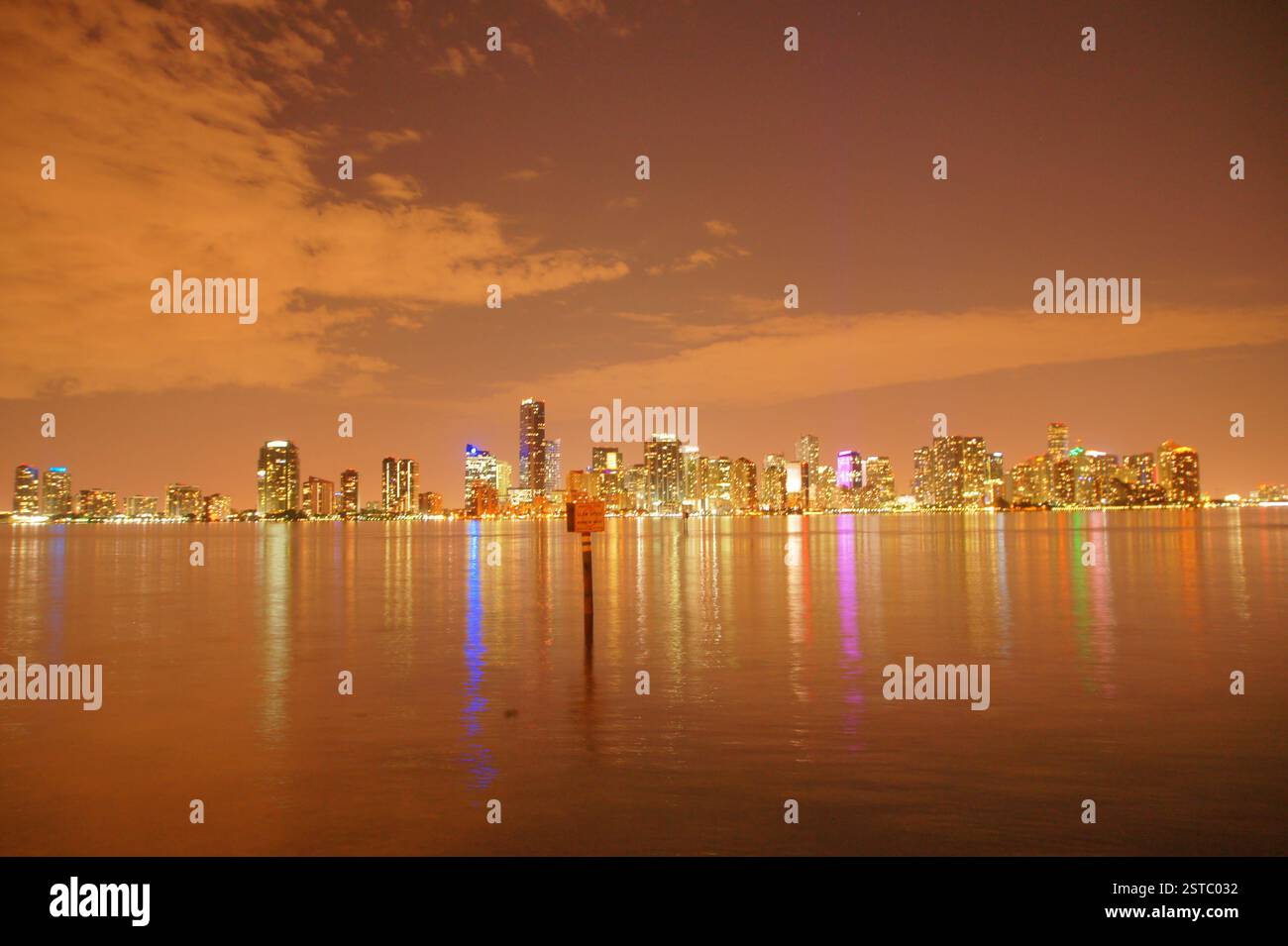 Miami skyline at night, seen from across a body of water. The city ...