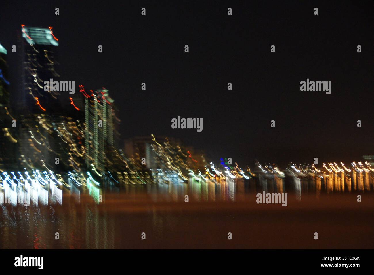 Blurry city skyline at night Miami. Dark sky with glowing lights from ...