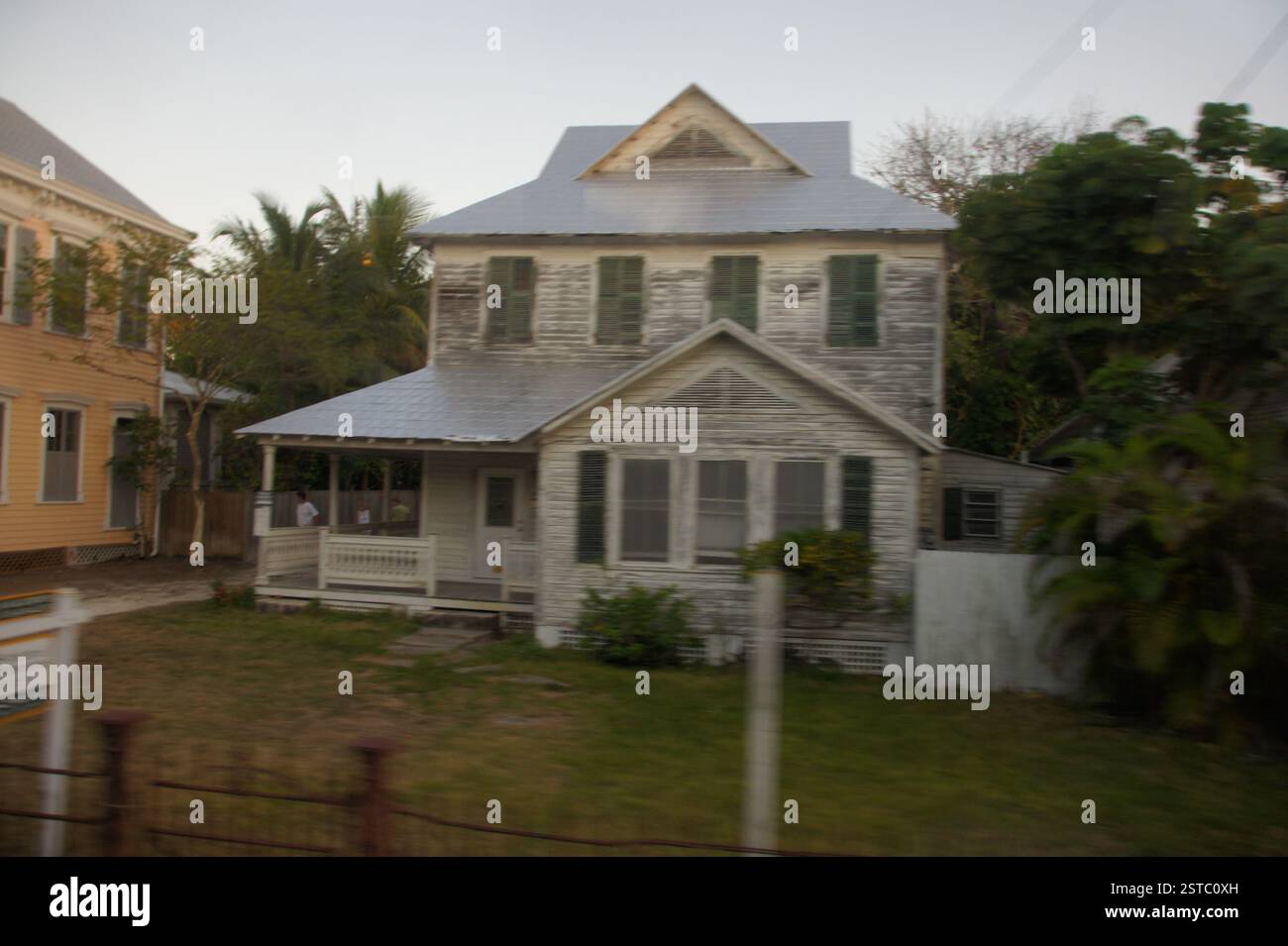 White house with green shutters and metal roof in rural area. Miami ...