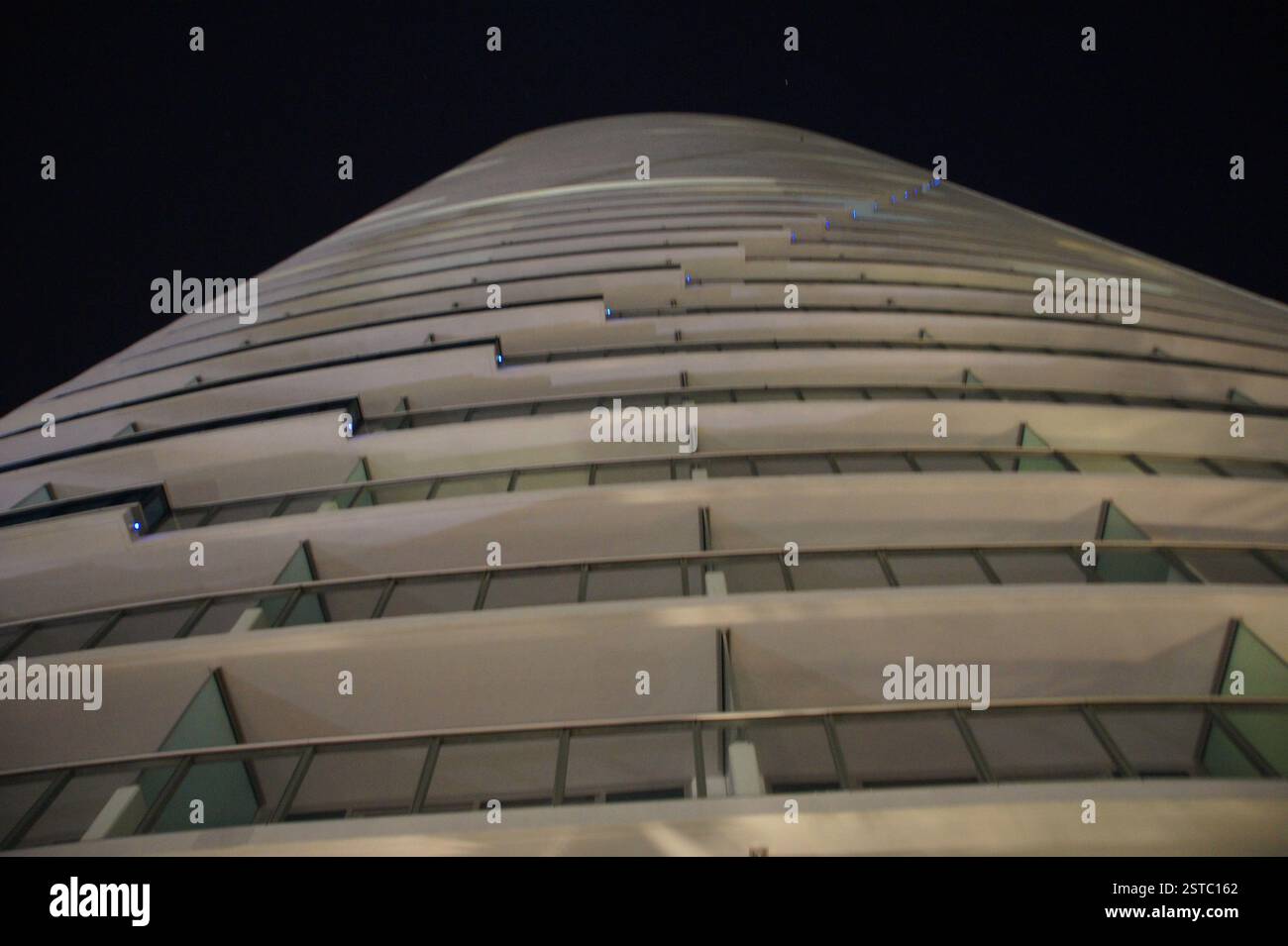 Miami high-rise building illuminated with warm yellow lights at night ...