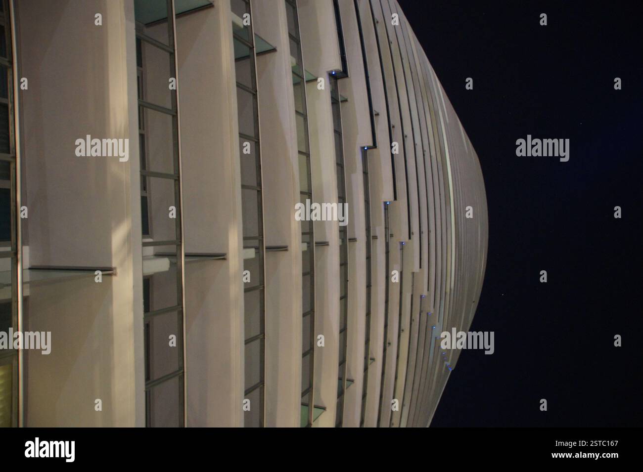 A towering skyscraper in Miami, its windows glowing brightly against ...