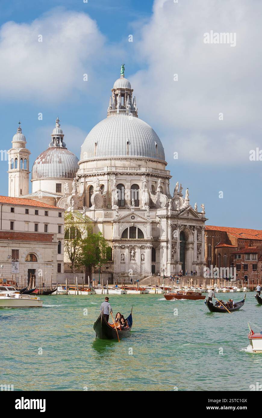 Tourism in Venice. Tourists on gondola cross the Grand Canal in front ...