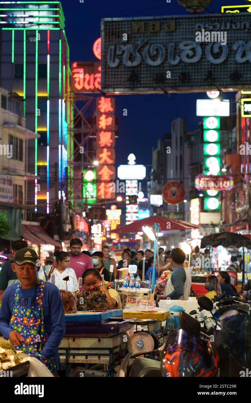 Vibrant night scene in Bangkok's Chinatown with neon-lit Yaowarat Road bustling with market ...