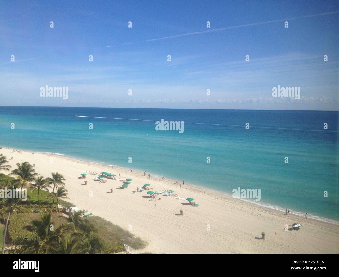 Miami beach scene. Crowded with people and colorful umbrellas lining ...