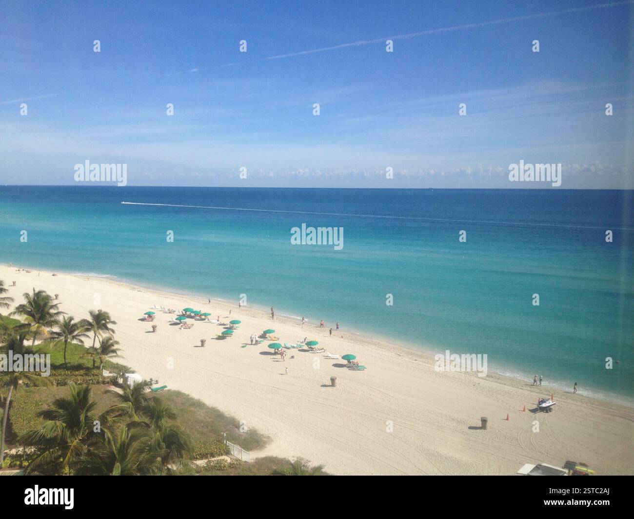 Miami beach scene. Crowded with people and colorful umbrellas lining ...