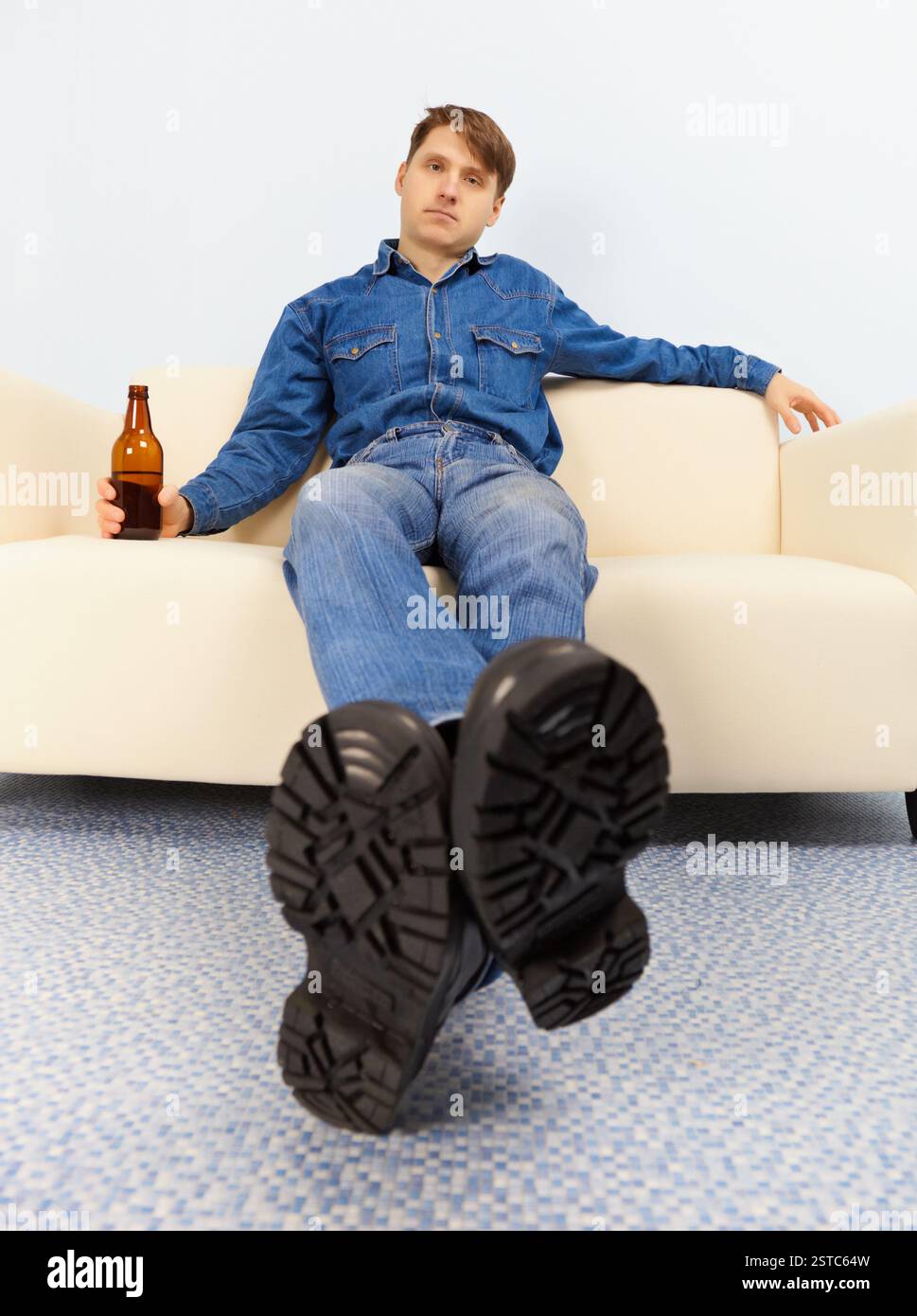 Drunk dude sprawled on couch Stock Photo - Alamy