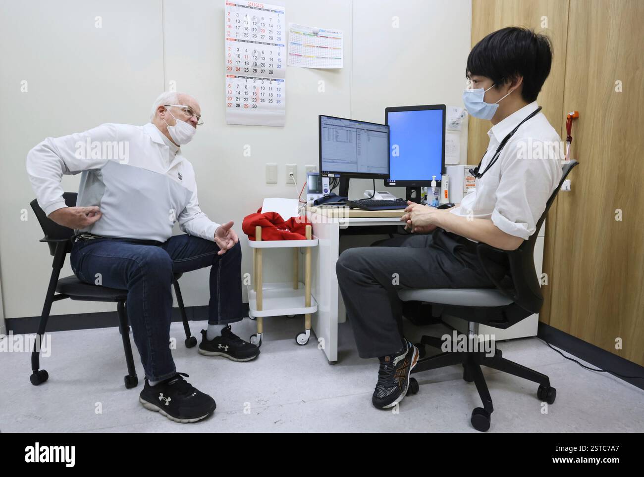 An American man (L) receives a medical examination from a Japanese ...