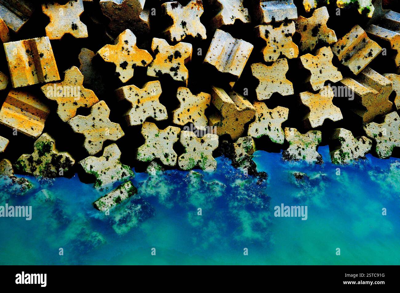 Weathered concrete block seawall and blue water Stock Photo - Alamy