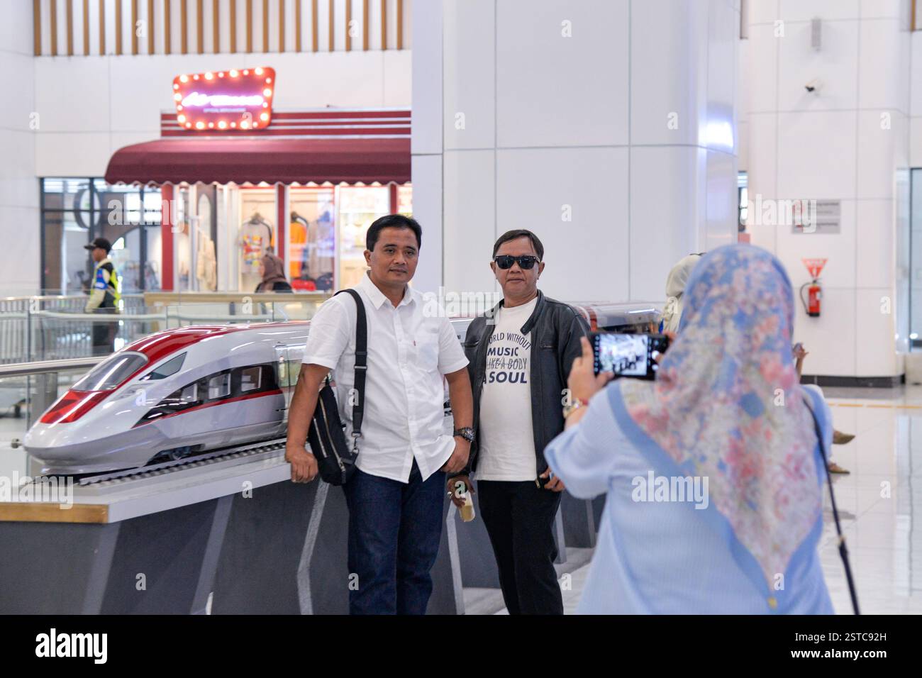 Jakarta, Indonesia. 17th Feb, 2025. Passengers pose for photos with a model of a high-speed ...