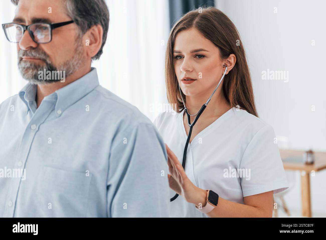 Woman using stethoscope and listening lungs of the man. Professional ...