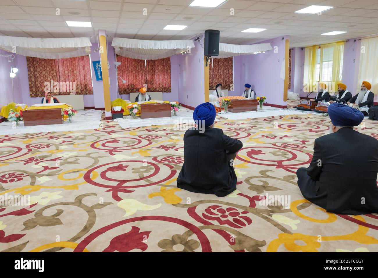 2 older men listen to a reading of the Guru Granth Shaib Sikh bible ...