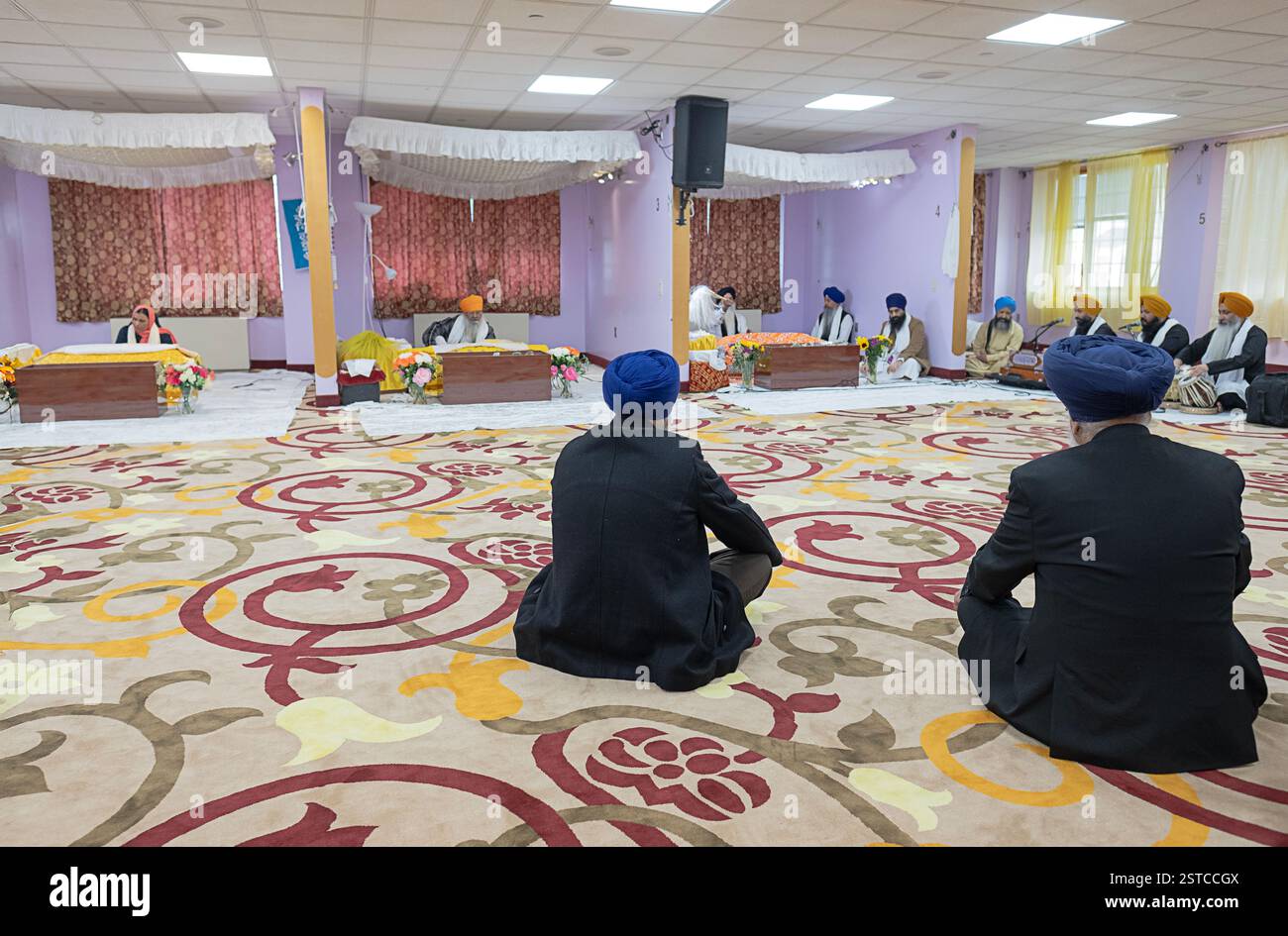 2 older men listen to a reading of the Guru Granth Shaib Sikh bible ...