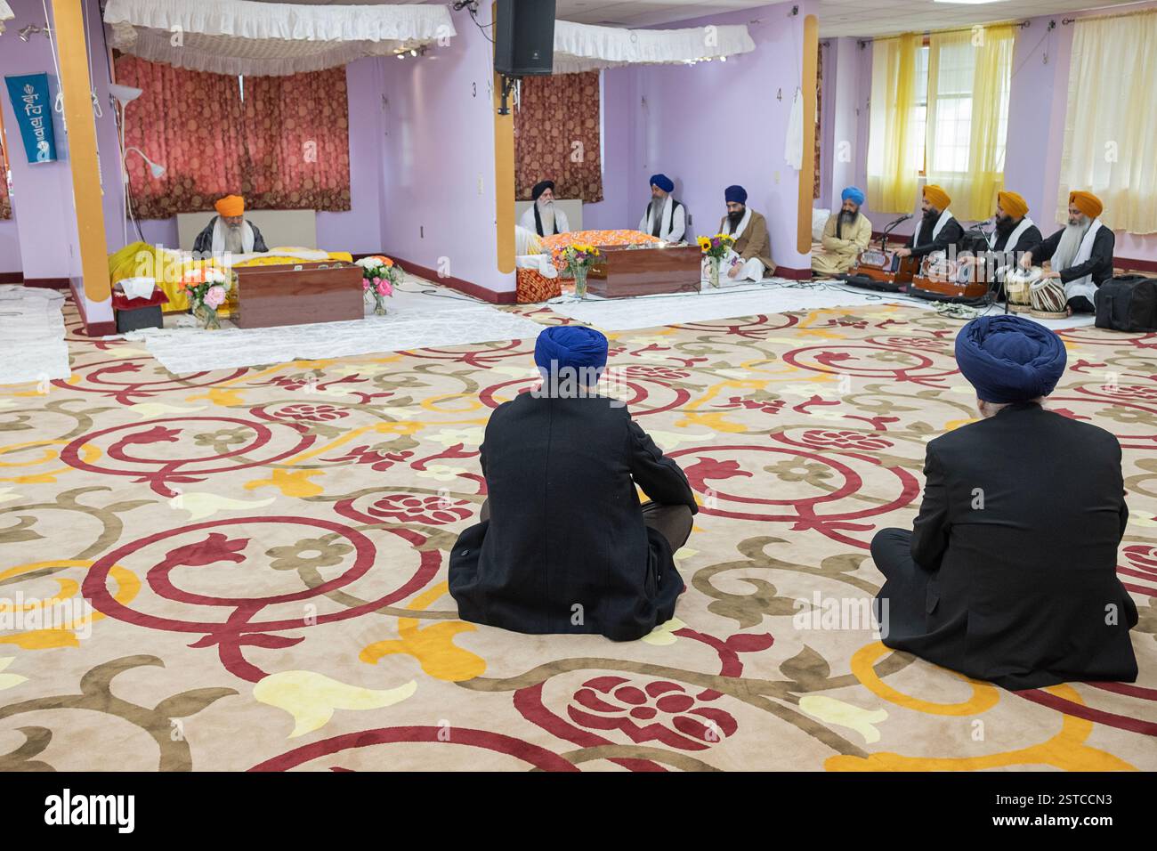2 older men listen to a reading of the Guru Granth Shaib Sikh bible ...