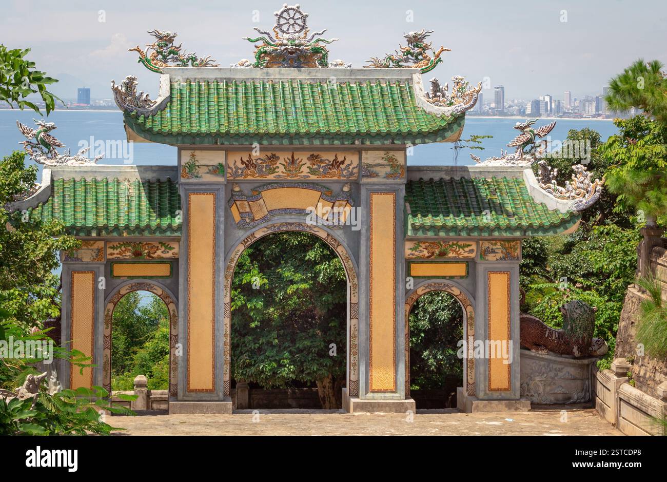 Traditional colorful Asian gate structure and tropical forest coastline ...