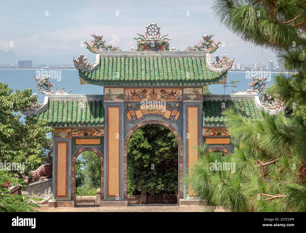 Traditional colorful Asian gate structure and tropical forest coastline ...