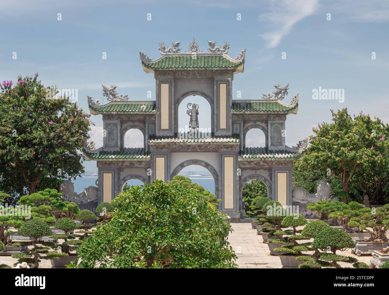 Traditional stone arch gate structure, garden, and tropical forest ...