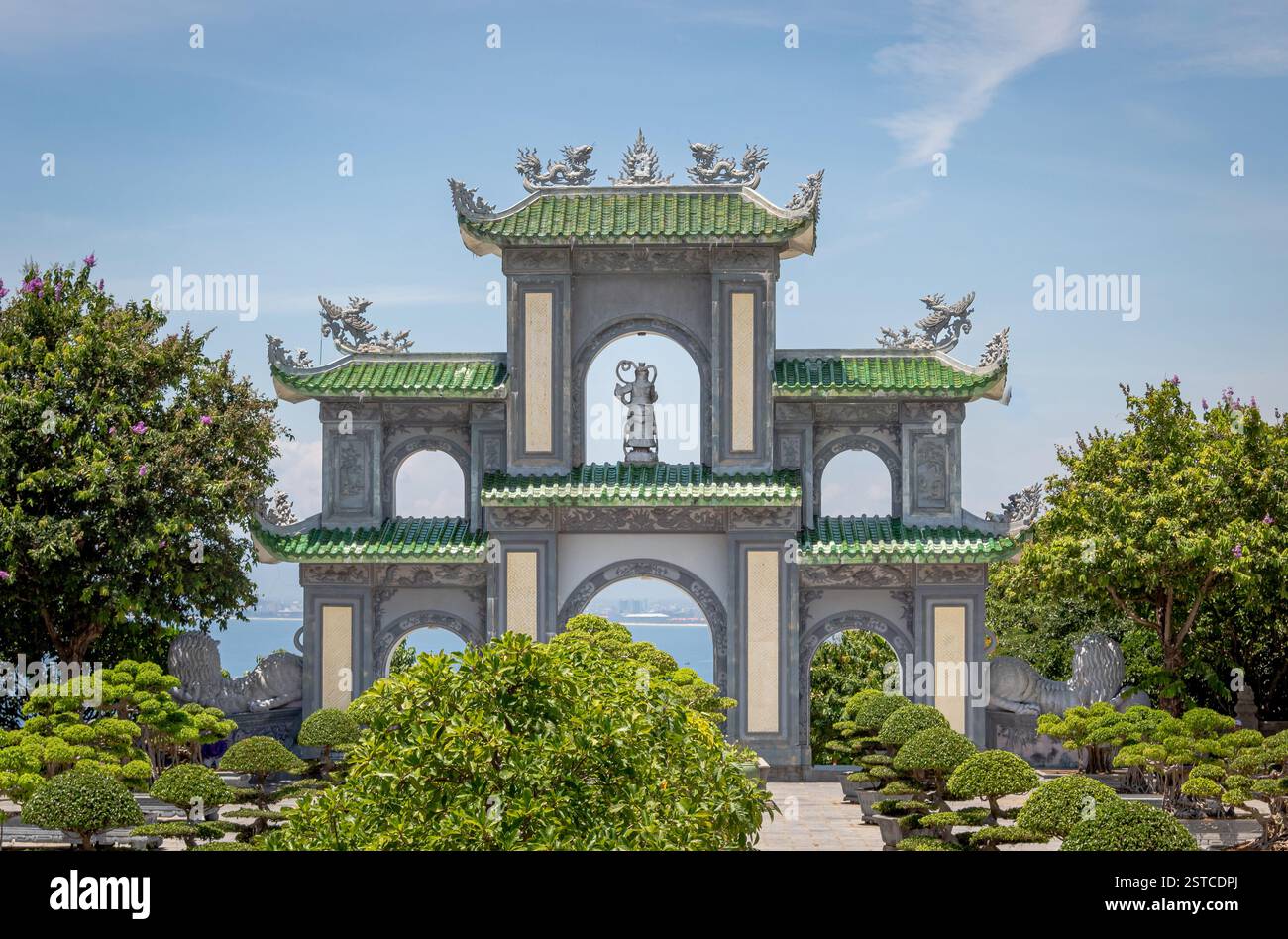 Traditional stone arch gate structure, garden, and tropical forest ...