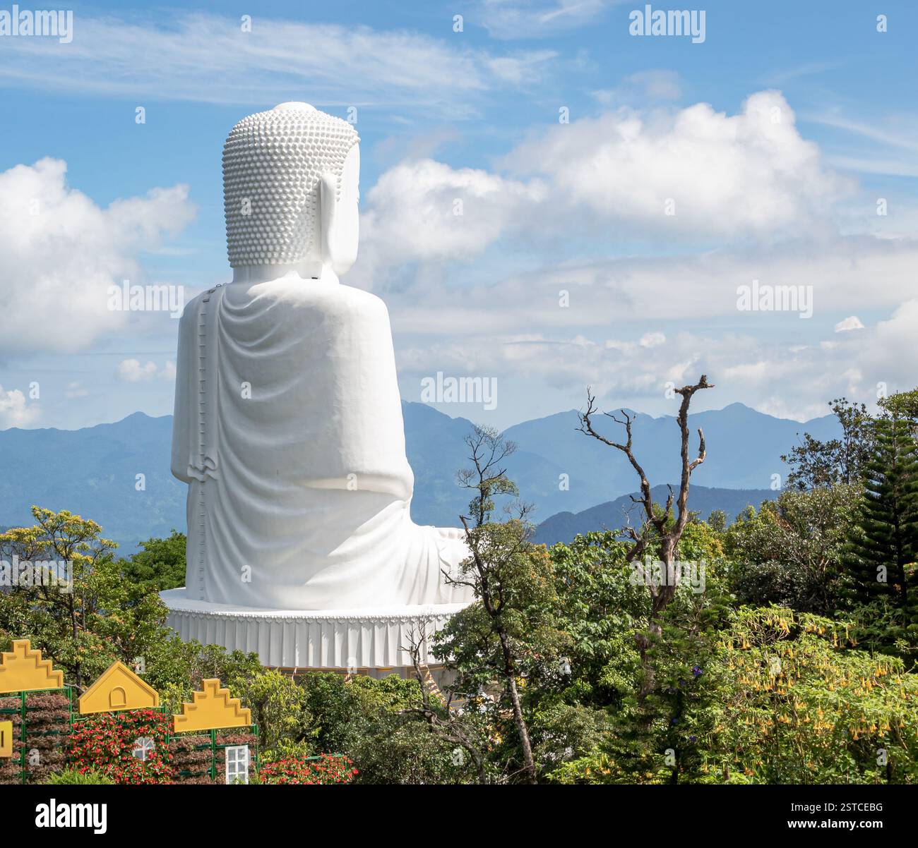 White seated Buddha statue in a garden at a Buddhist temple at the Ba ...