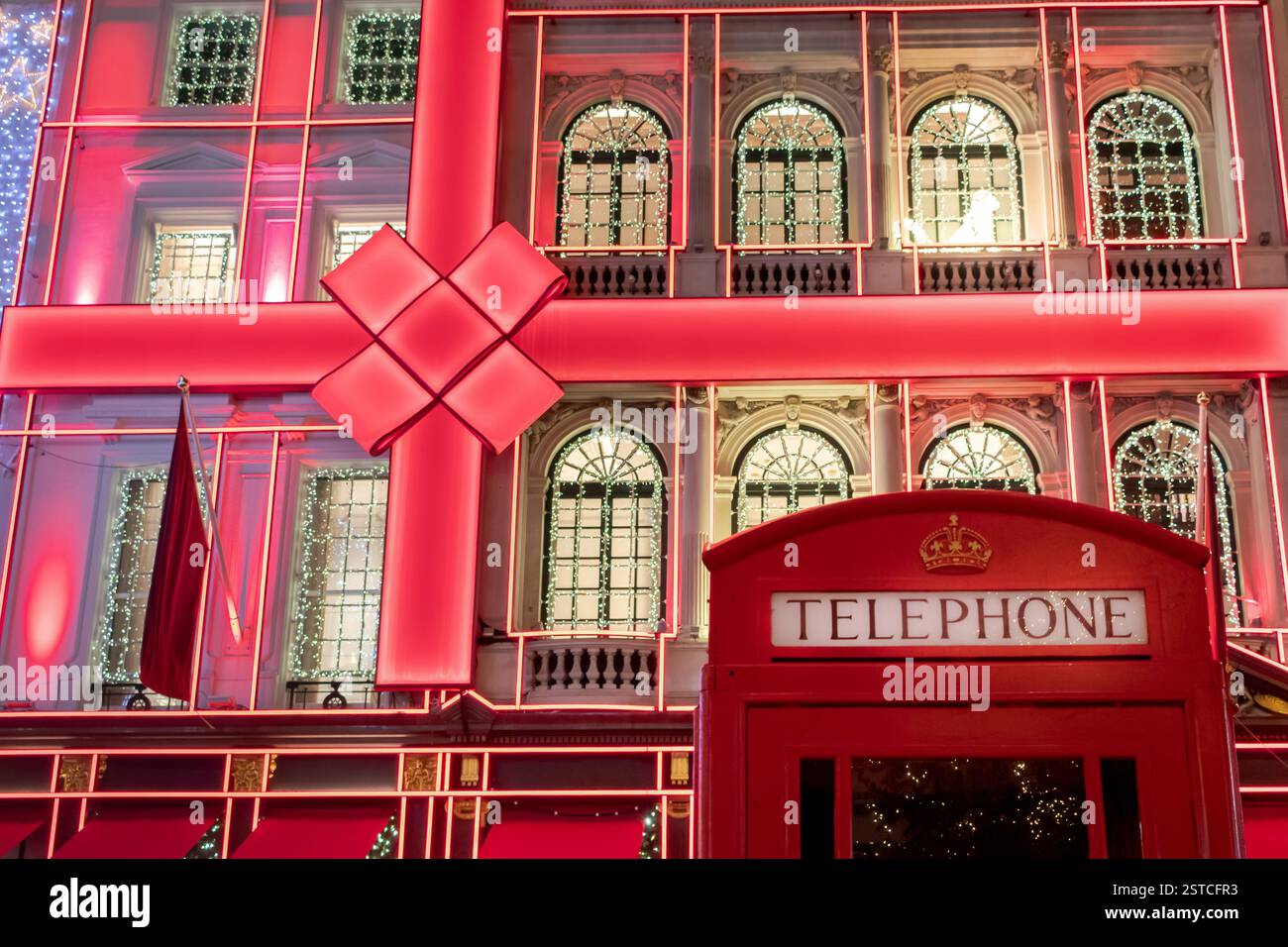 Illuminated lighted up decorated department store front and iconic red ...