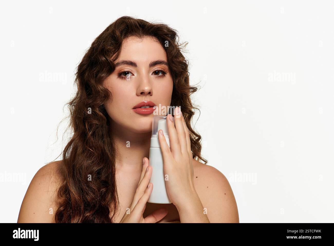 A charming young woman showcases a skincare product with elegance and ...