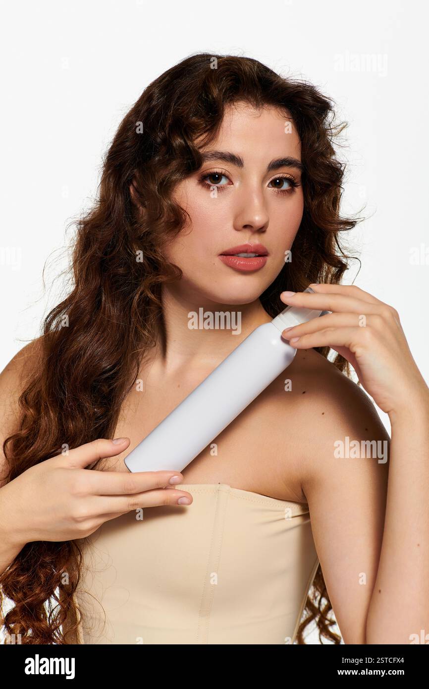 A young woman poses elegantly with a beauty product, radiating ...