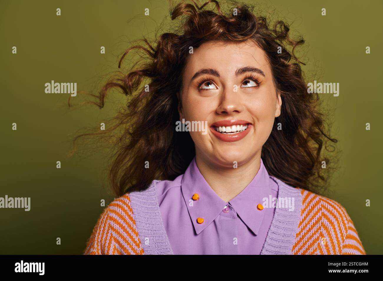 A brightly dressed woman smiles joyfully, flaunting her curls and ...