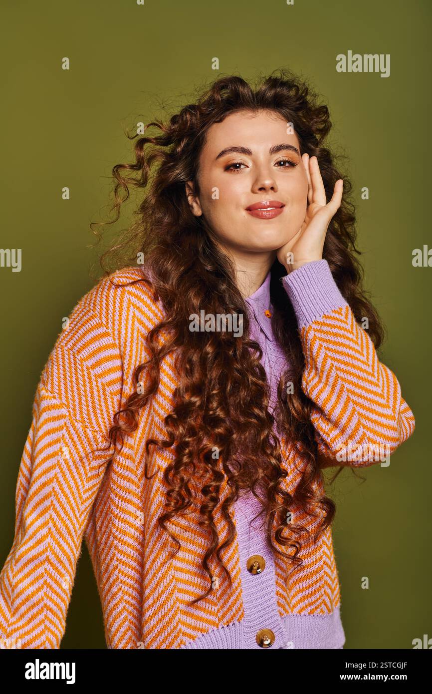 A stylish young woman flaunts her curls and bright cardigan in a ...
