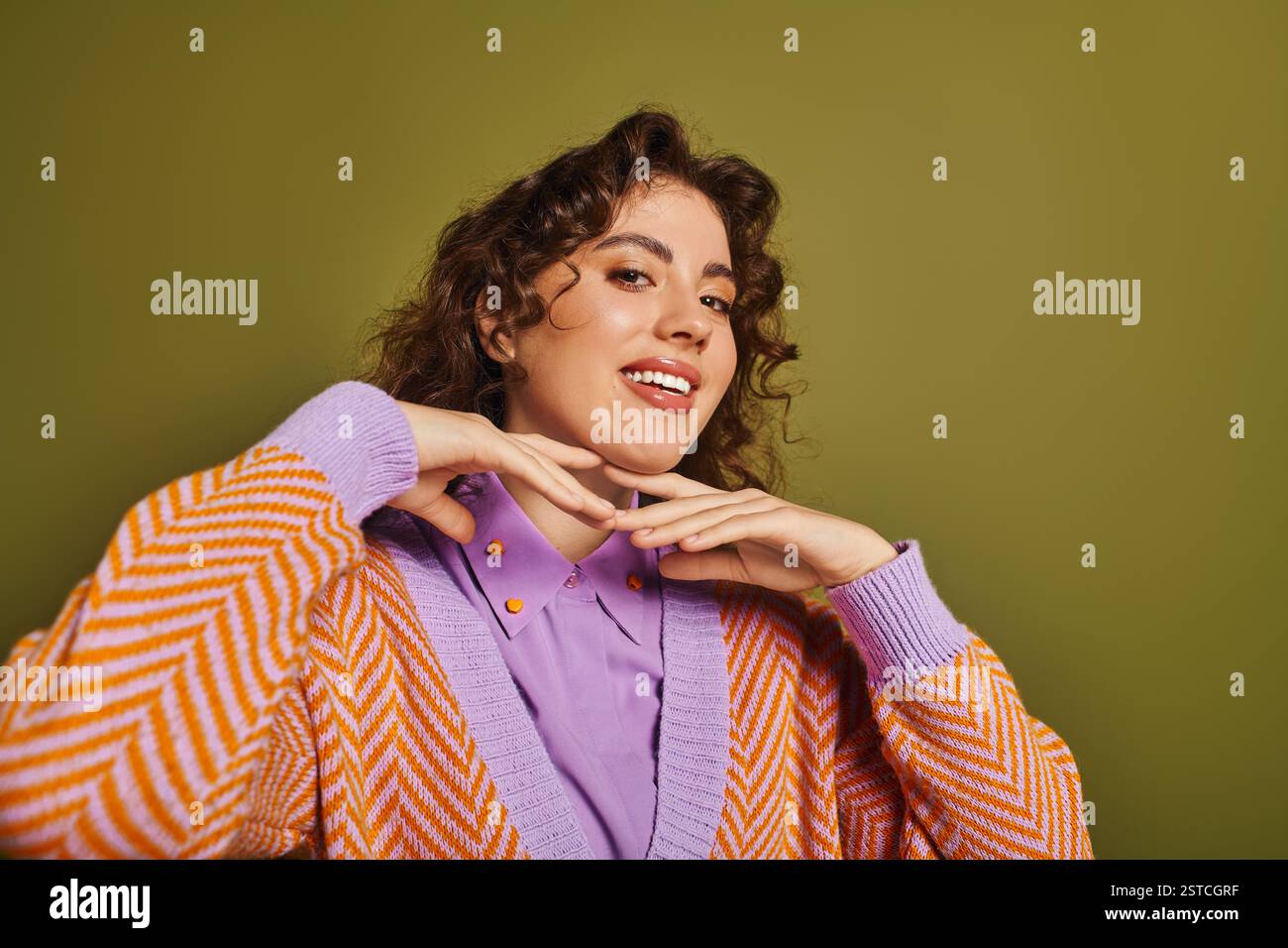 A young and stylish woman poses playfully, displaying her vibrant ...