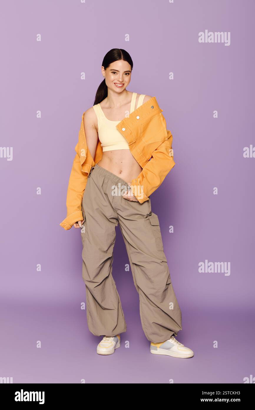 A stylish young woman shows off her chic look with a playful smile and ...