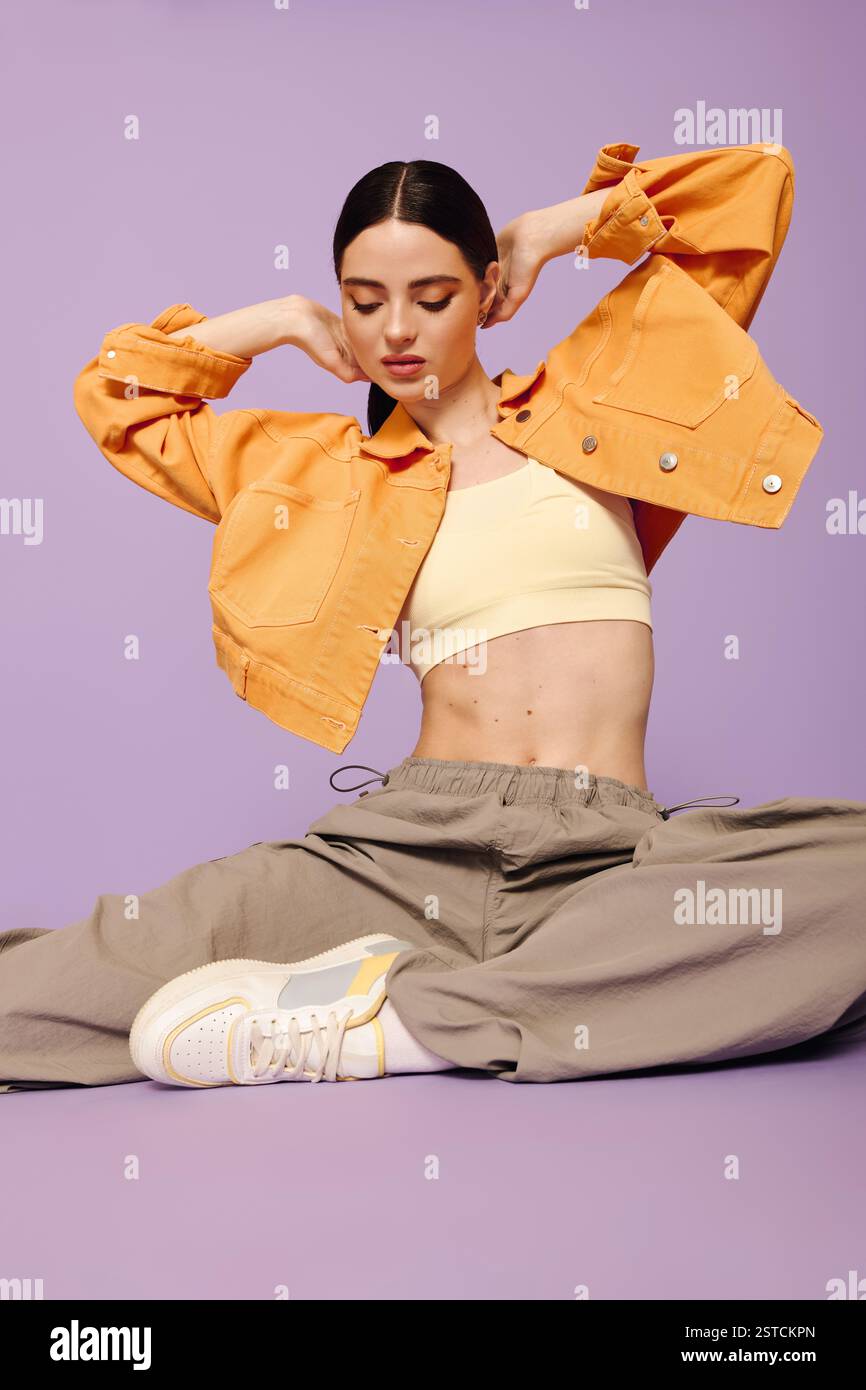 A young woman embraces her stylish side while striking a dynamic pose ...