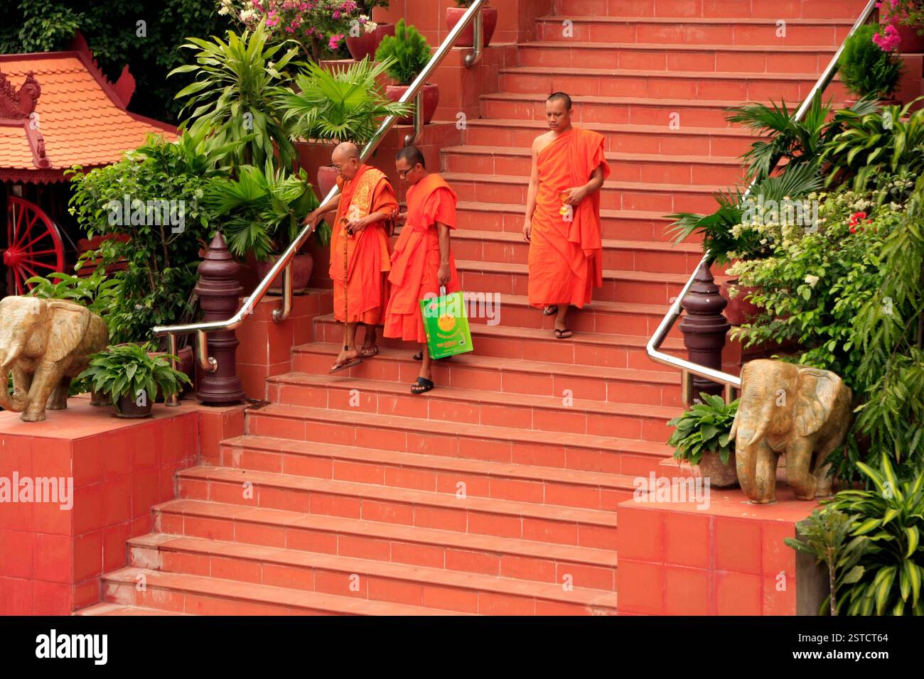 Three buddhist monks coming down temple's steps Stock Photo - Alamy