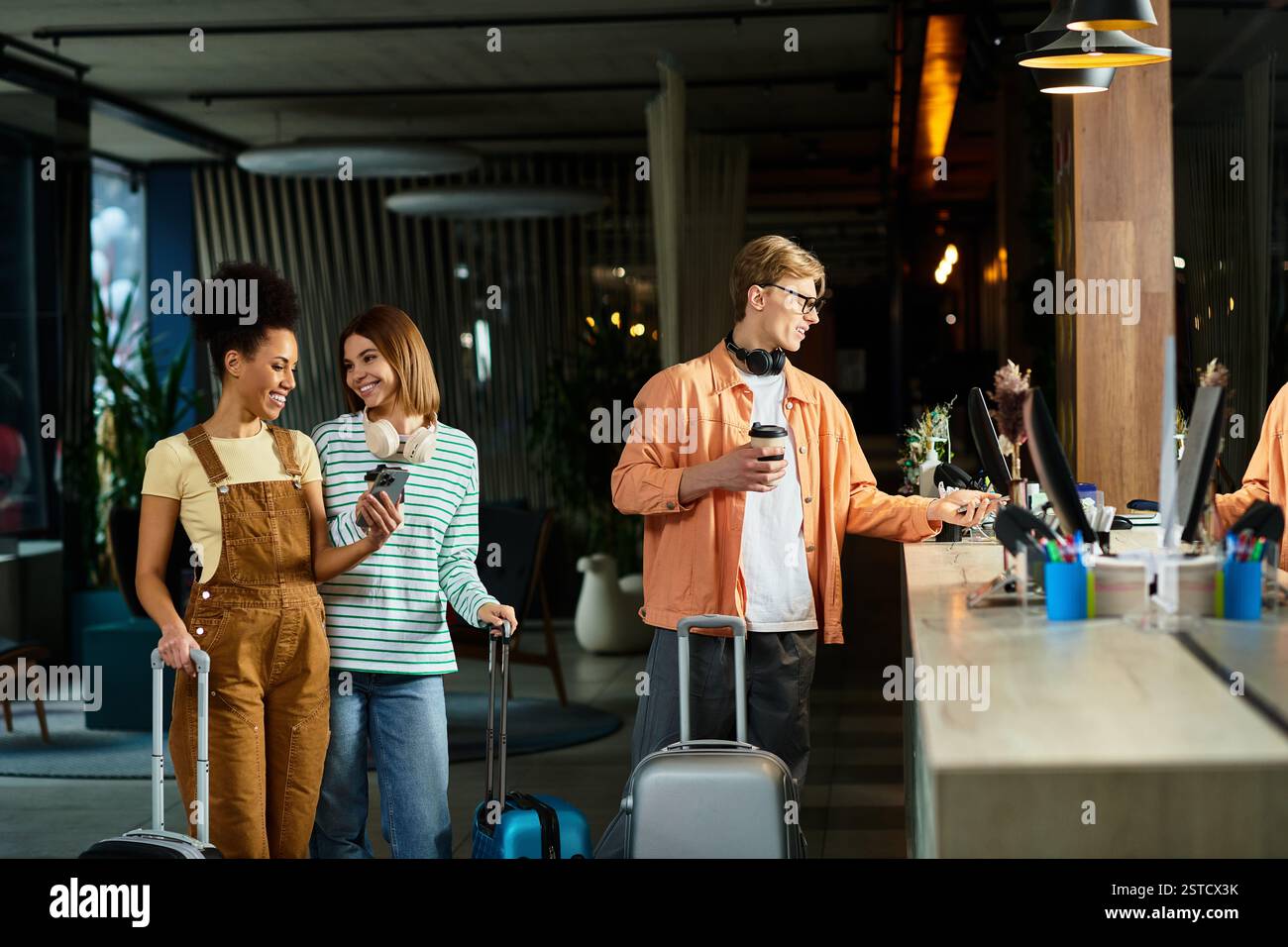 Three colleagues chat and check in at a stylish hotel lobby, sharing ...
