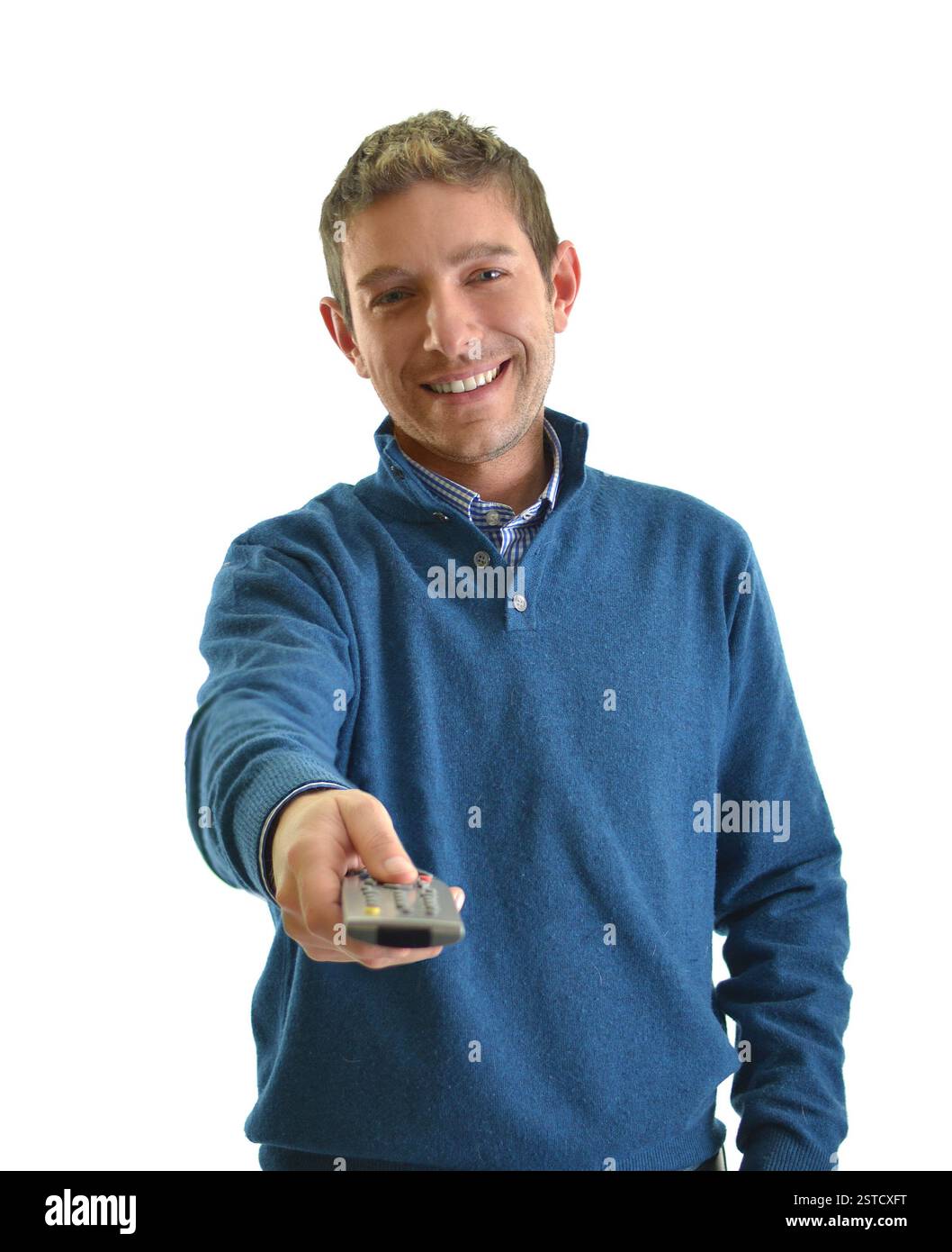 Smiling young man pointing TV remote control Stock Photo - Alamy
