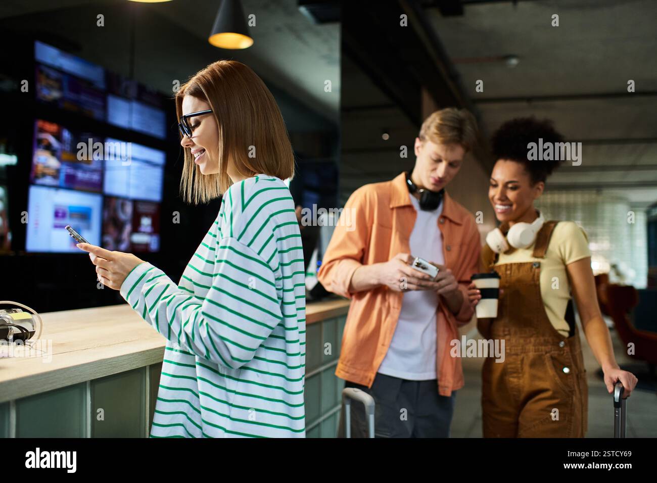 Three colleagues engage in cheerful conversation while checking in at a ...