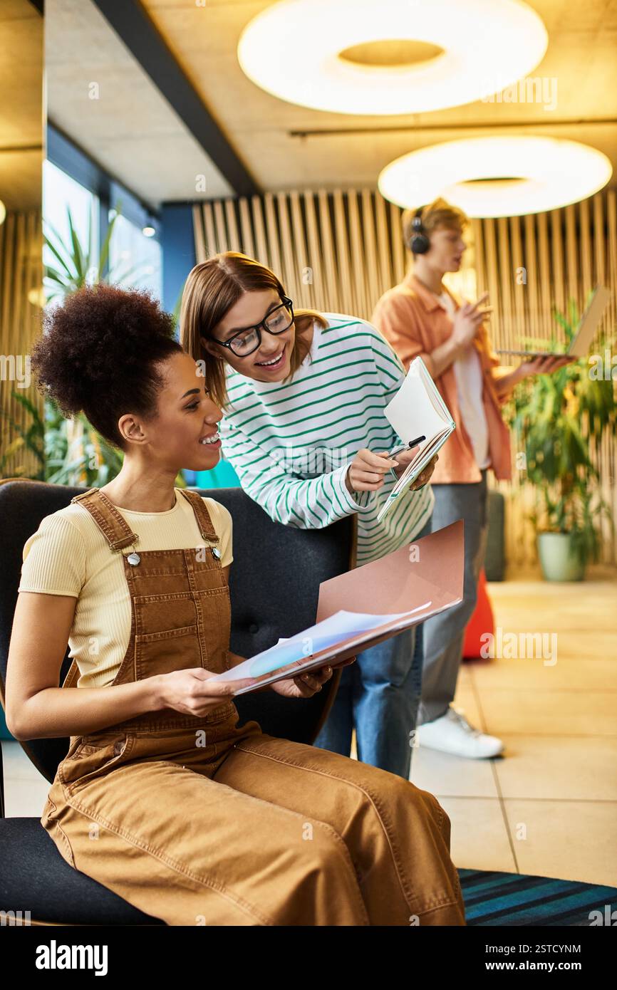 Two colleagues share ideas while another works diligently in a lively ...