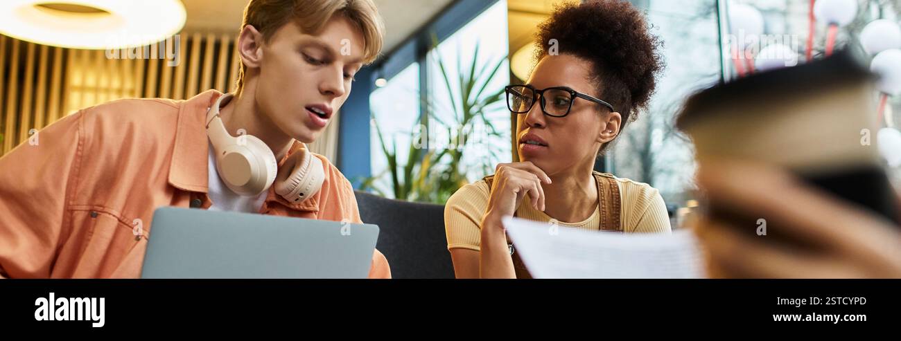 Two colleagues engage in a focused discussion while working at a hotel ...
